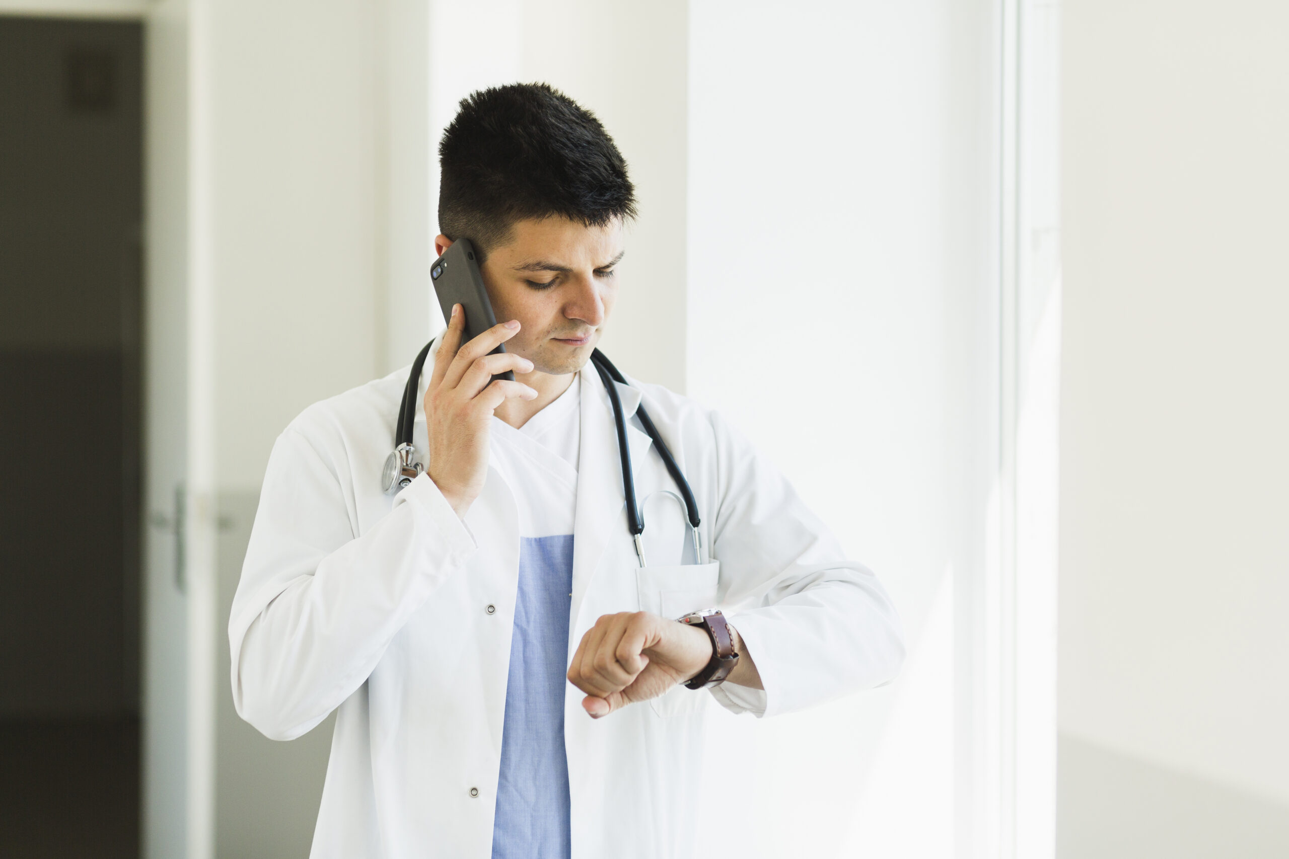 doctor-making-phone-call-checking-time - Docs Medical Group
